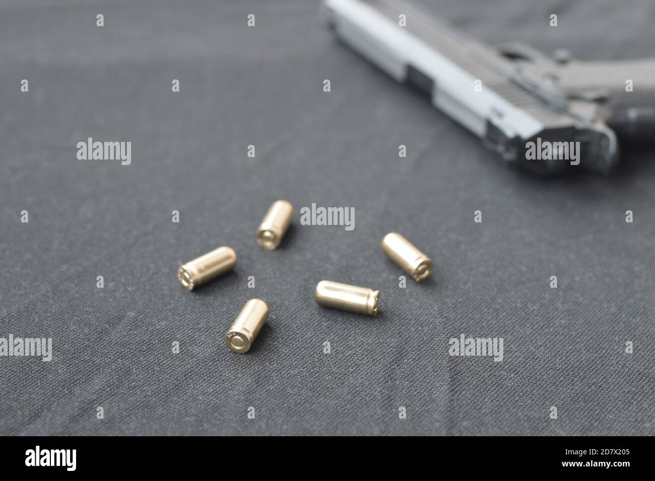 9mm bullets and pistol lie on a black fabric. A set shooting range ...