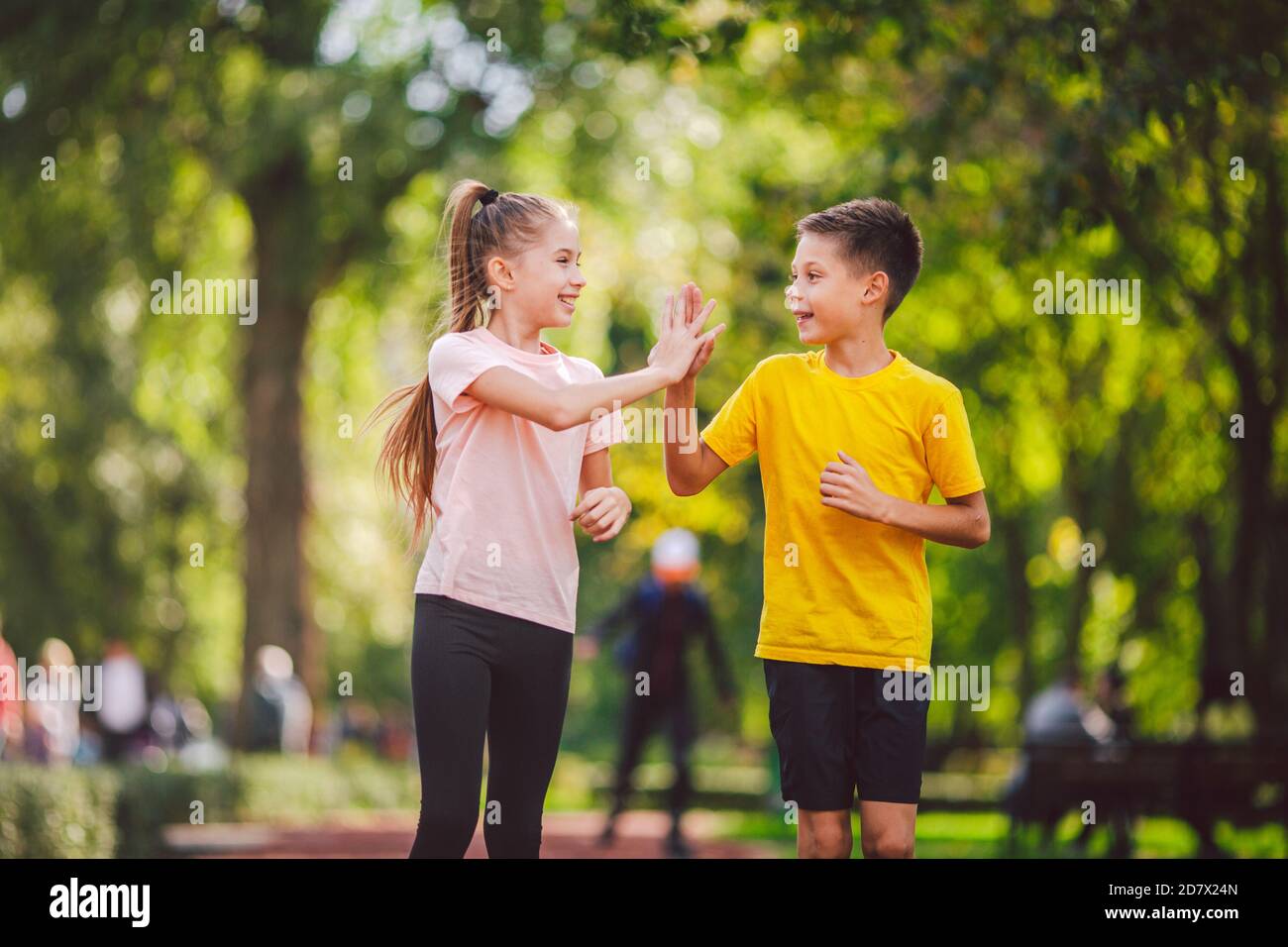 Sports and fitness in adolescence. Caucasian twins boy and girl run on ...