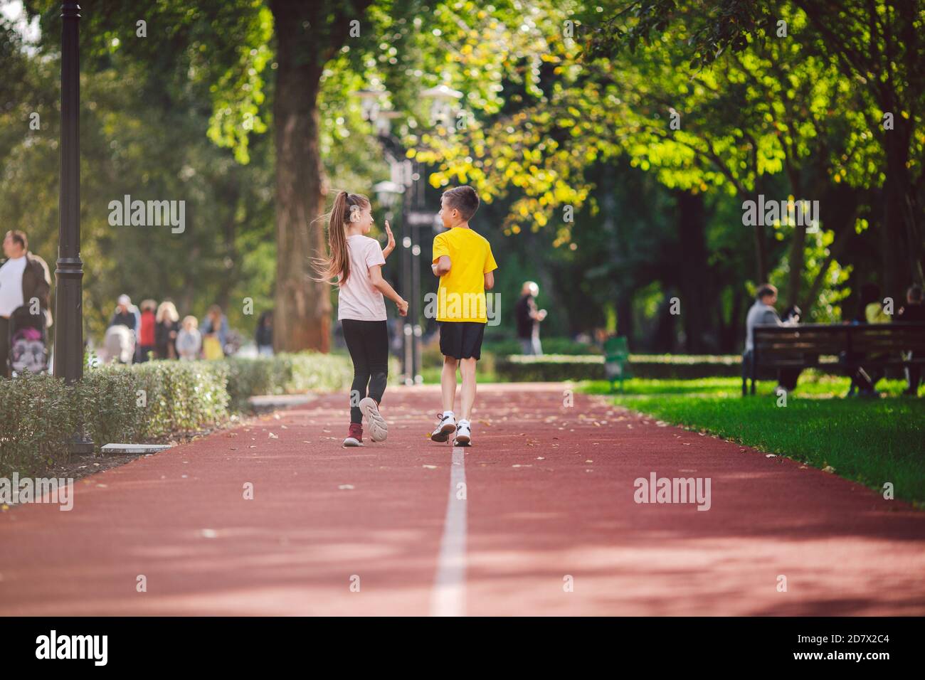 Sports and fitness in adolescence. Caucasian twins boy and girl run on ...