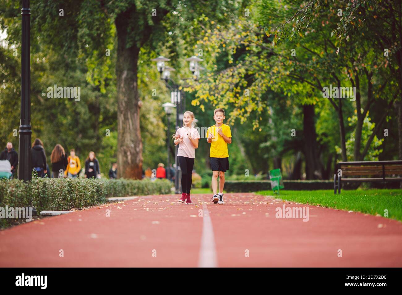 Sports and fitness in adolescence. Caucasian twins boy and girl run on ...