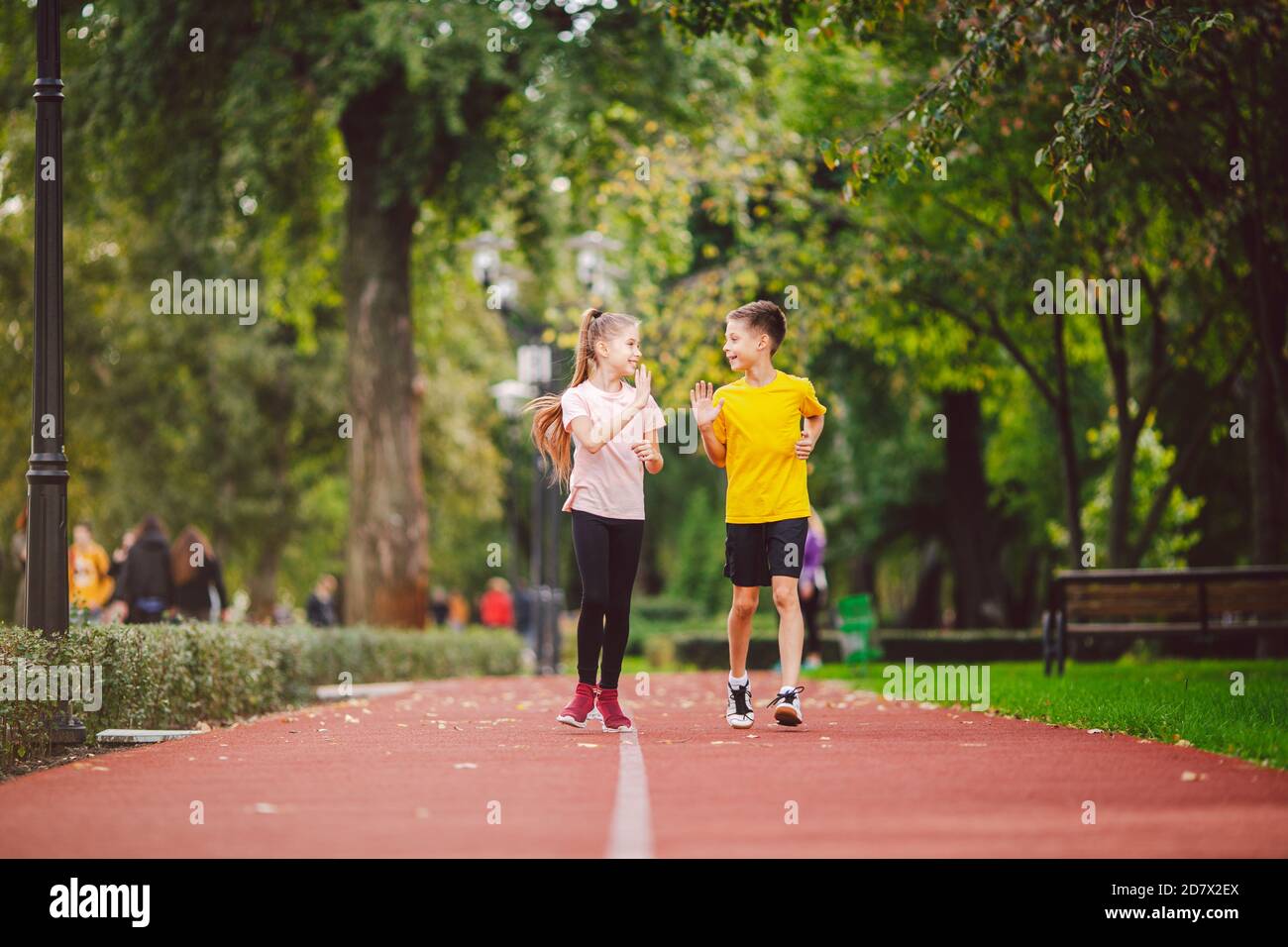Sports and fitness in adolescence. Caucasian twins boy and girl run on ...