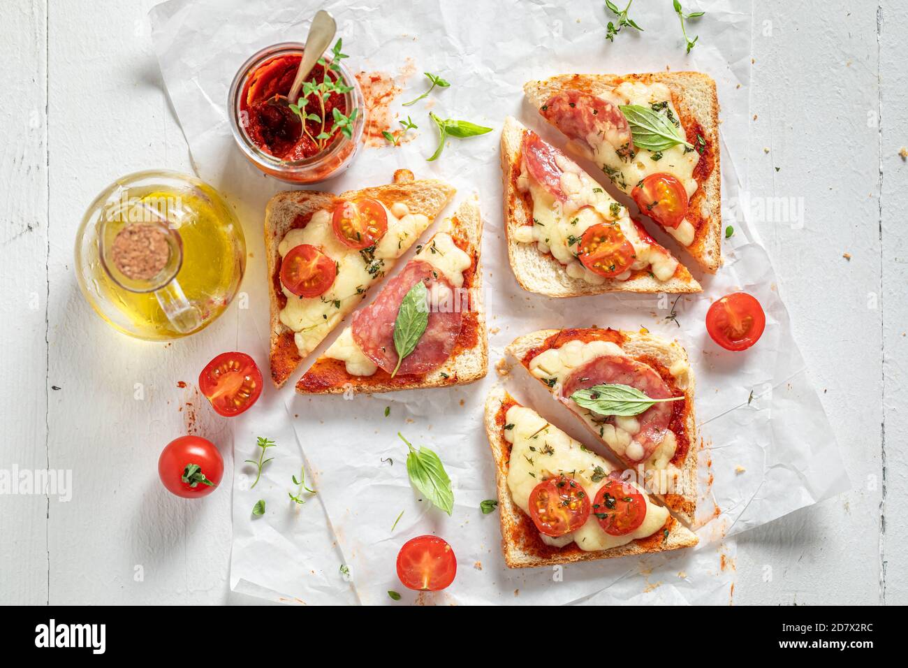 Rustic Toast with cheese, salami and basil on white paper Stock Photo ...
