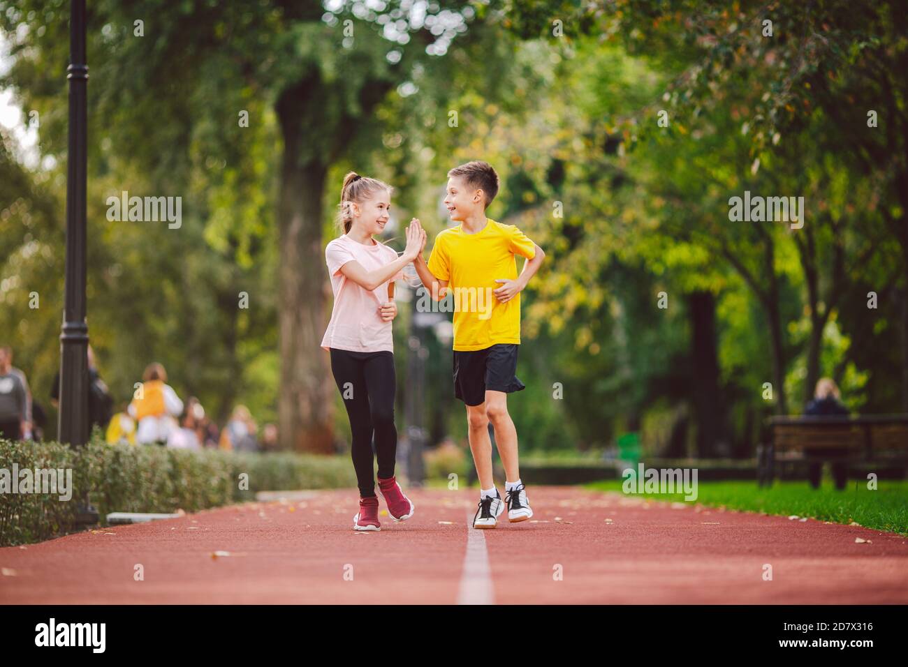 Sports and fitness in adolescence. Caucasian twins boy and girl run on ...