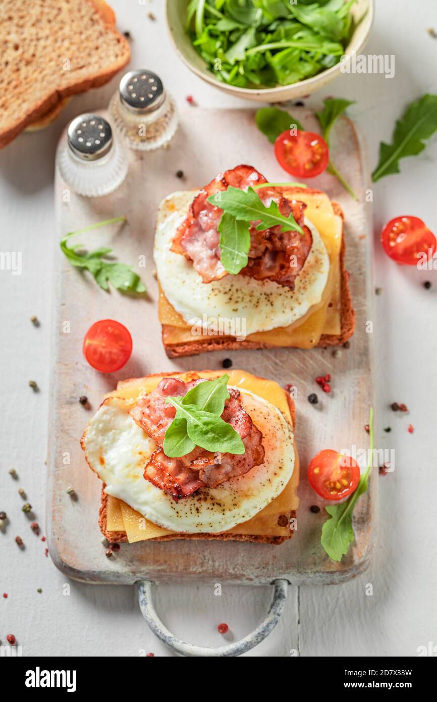 Homemade toast with egg, bacon and cheese on white board Stock Photo ...
