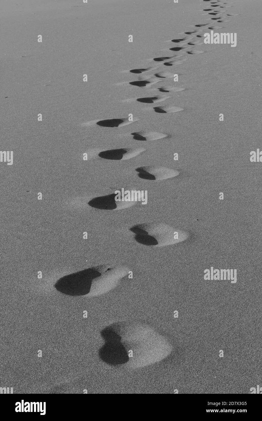 A single line of footsteps in the sand approaches the viewer Stock ...