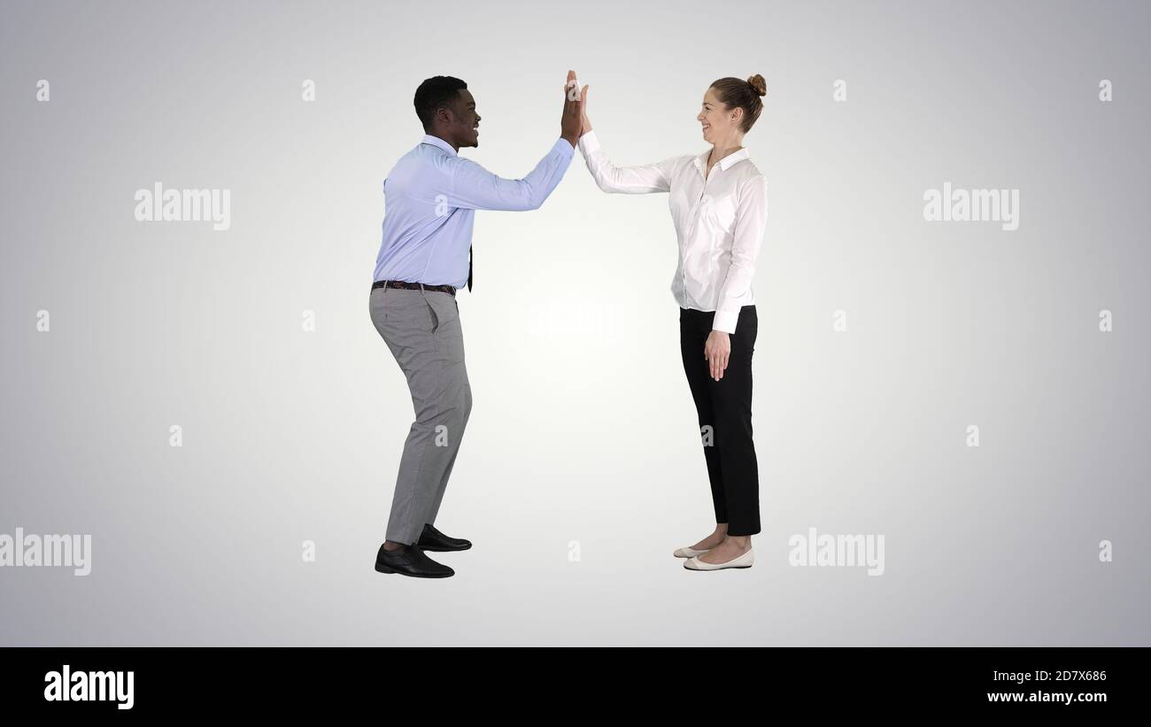 Young woman and young man in formal clothes give high five on gr Stock ...
