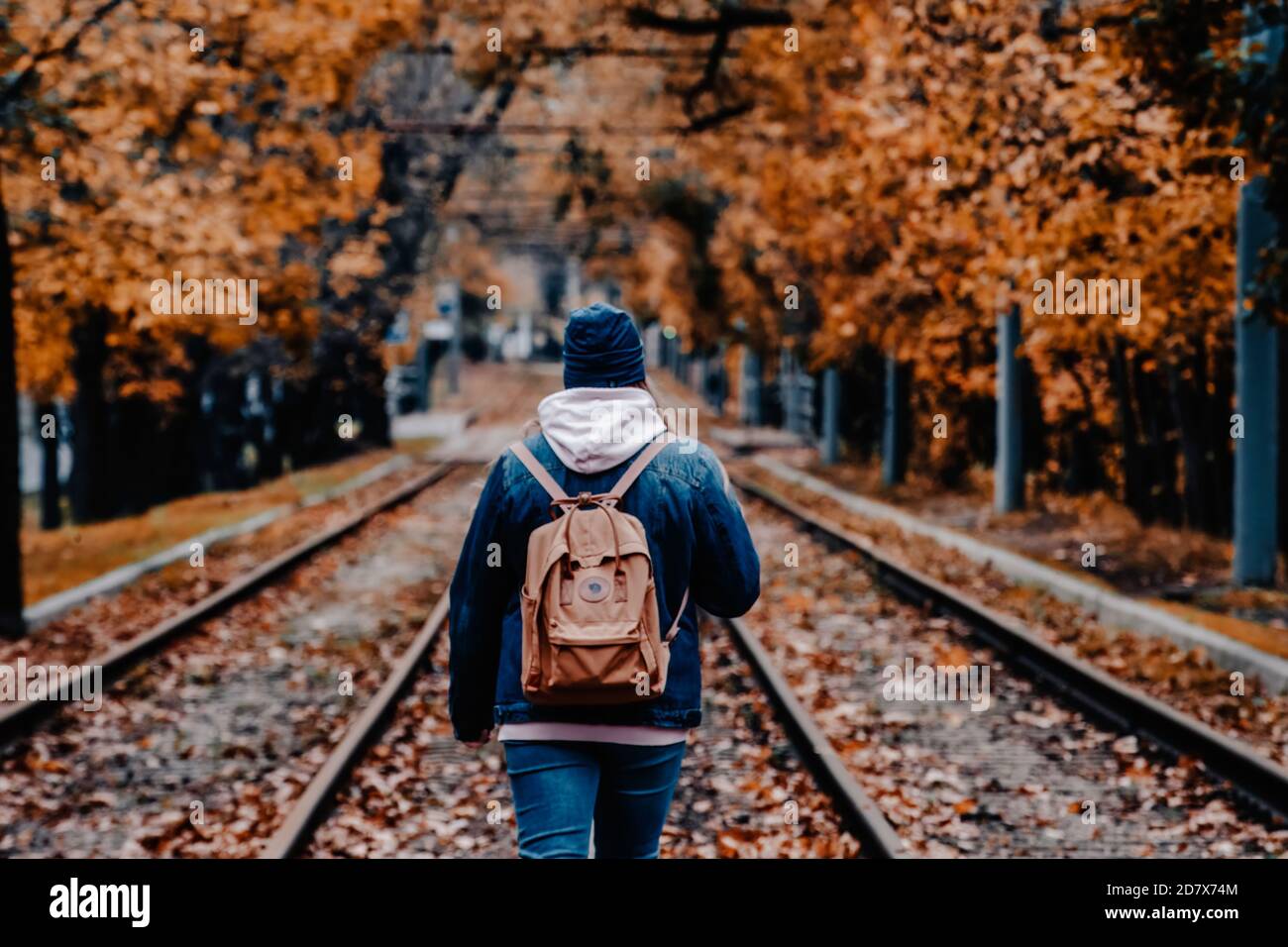 Girl is walking along the rails in the autumn city Stock Photo - Alamy