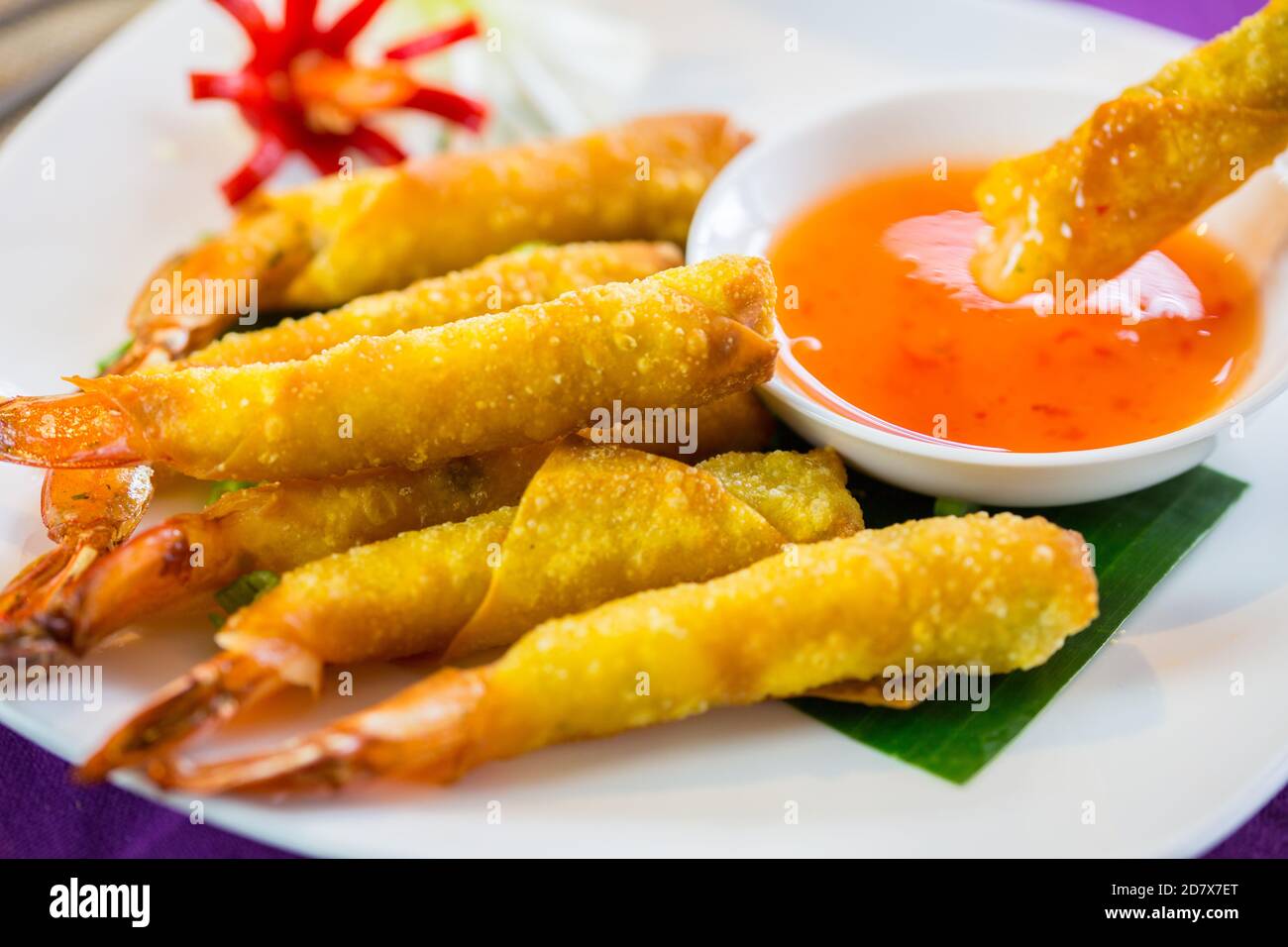 Prawn spring rolls dipping in sweet chilli sauce Stock Photo - Alamy