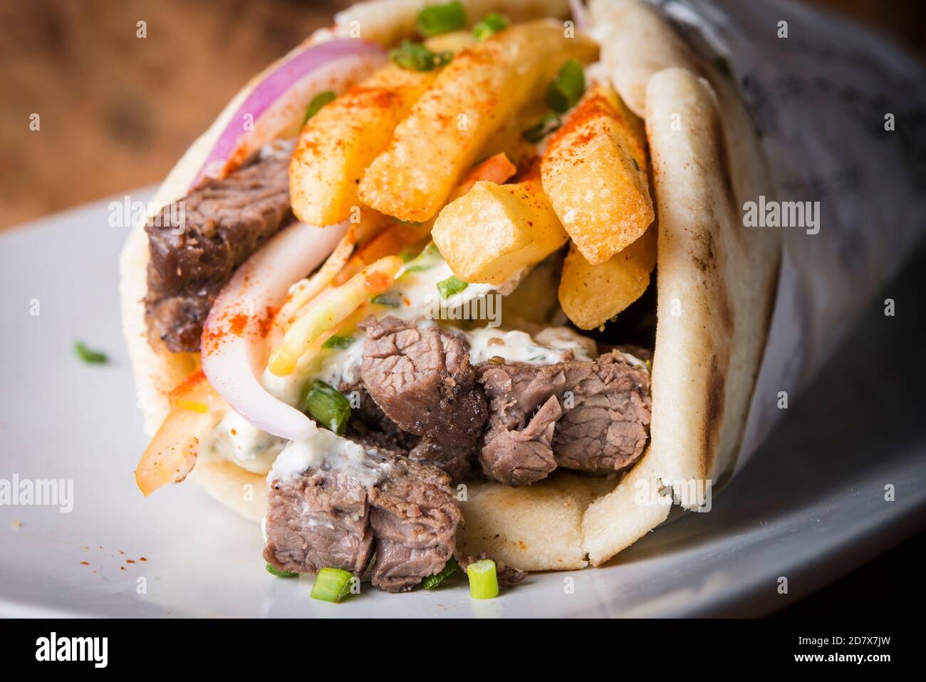 Beef gyros Greek style wrap in pita bread with french fries Stock Photo ...