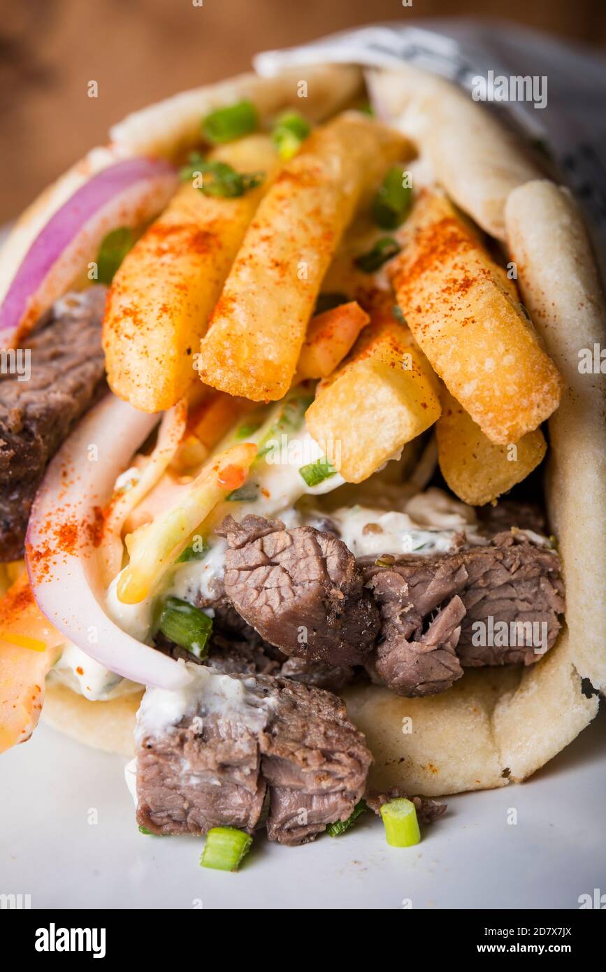 Beef gyros Greek style wrap in pita bread with french fries Stock Photo ...