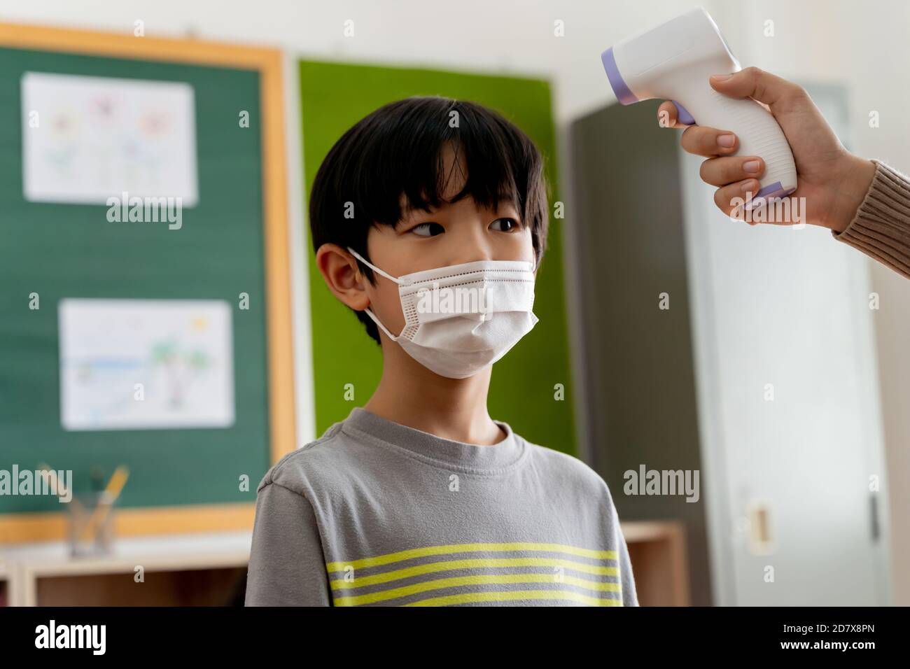 Asian male student in school building checked and scanned for ...