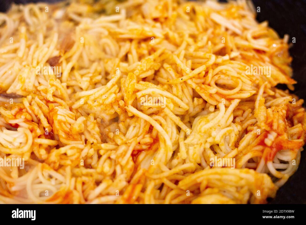 close-up of spaghetti mixed with fried tomato heating in a pan Stock ...