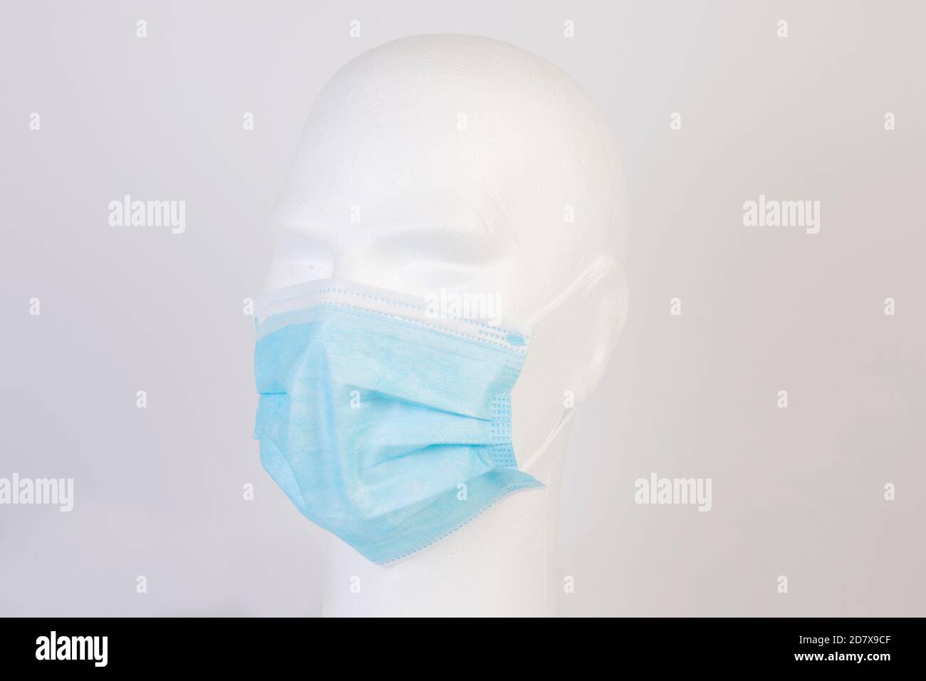 White bust of mannequin with blue hygienic mask on white background ...