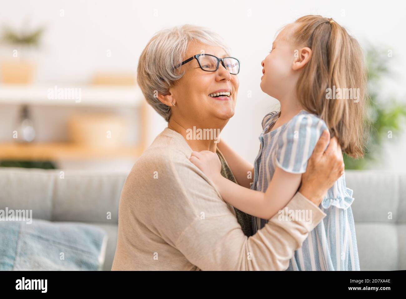 A nice girl and her grandmother enjoy sunny morning. Good time at home ...