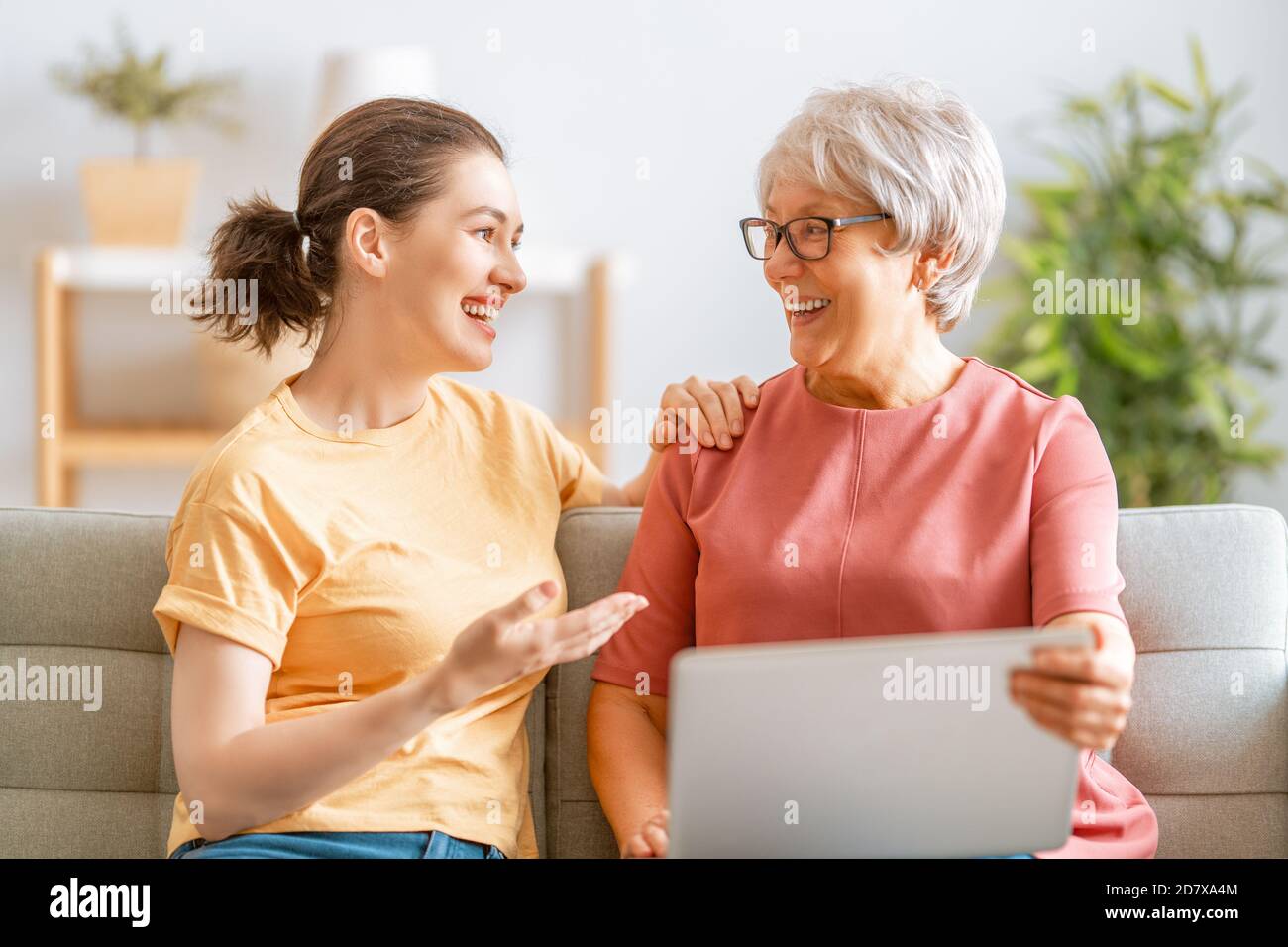 Young and senior women are using laptop pc. Daughter is helping mother ...
