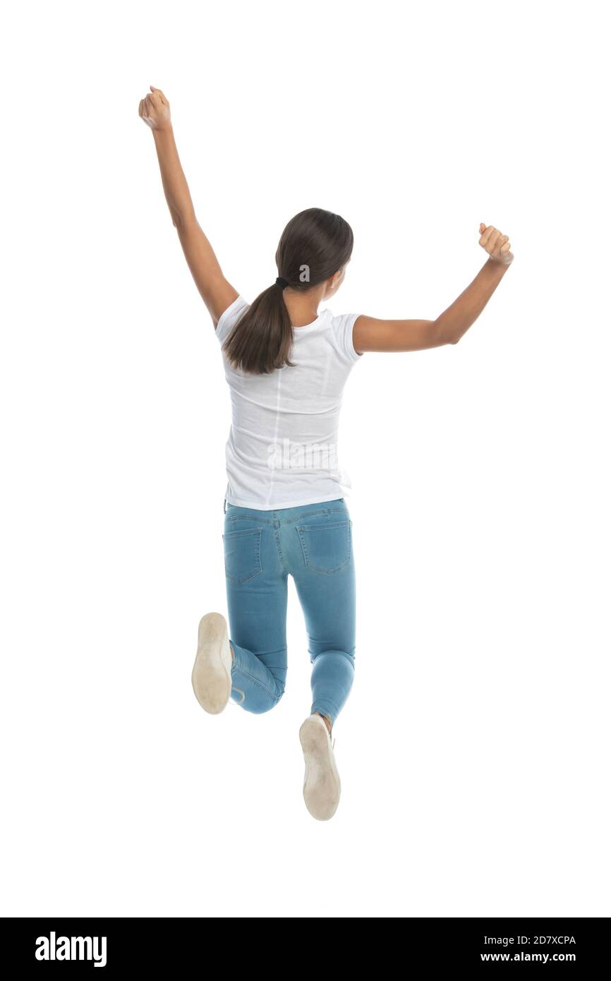 Back view of cheerful casual woman celebrating and jumping on white ...