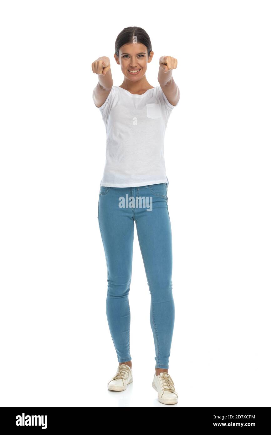 Positive casual woman pointing forward with both hands and standing on ...