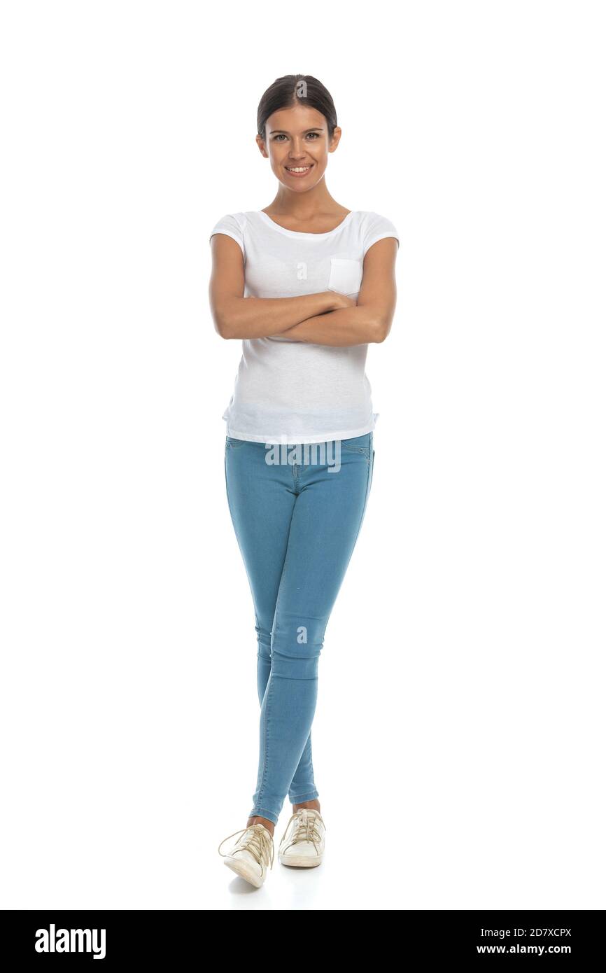 Positive casual woman smiling with hands and legs crossed, standing on ...