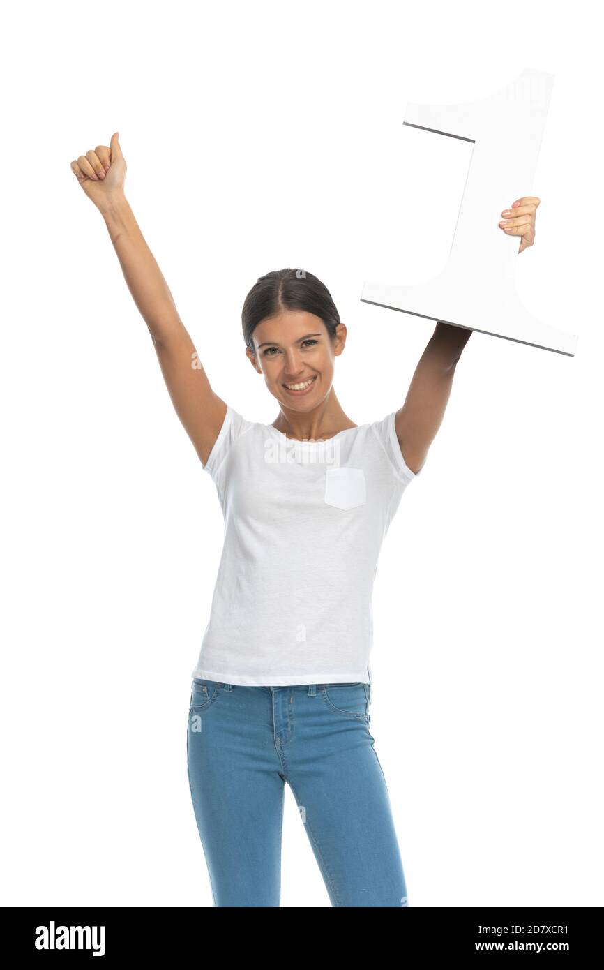Cheerful casual woman holding number one and celebrating while standing ... Cheerful casual woman holding number one and celebrating while standing ...