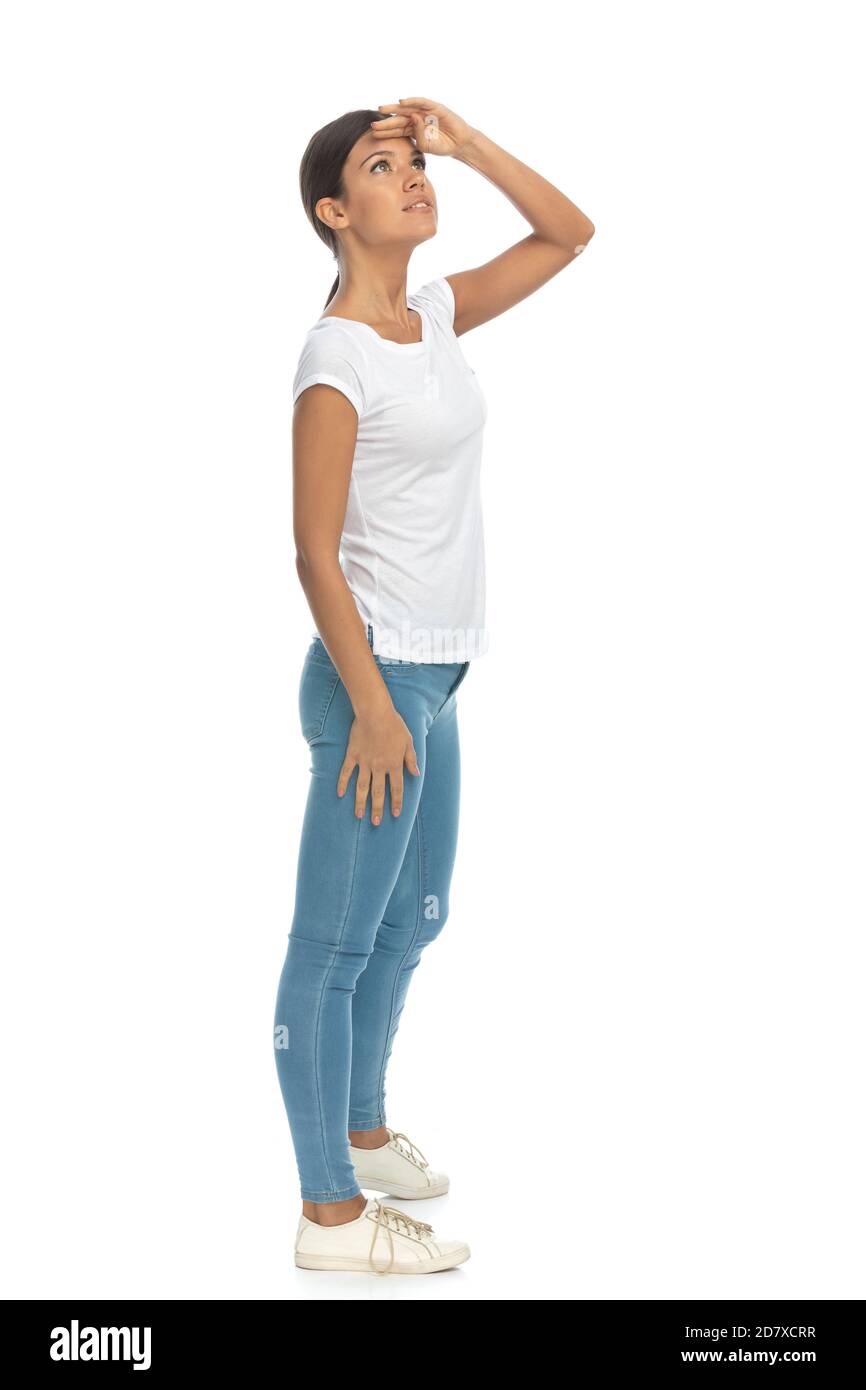 Side view of hopeful casual woman looking into distance, standing on ...