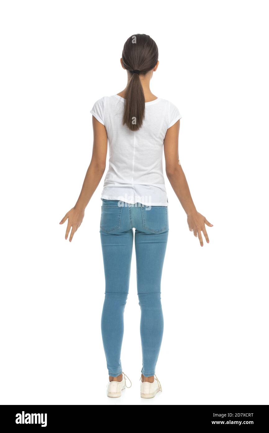 Back view of casual woman being surprised, standing on white studio ...