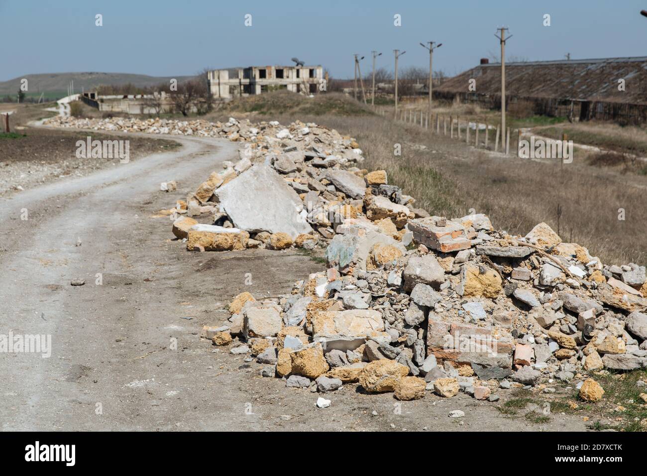 Old construction waste. Heaps of garbage lie along a dirt road ...