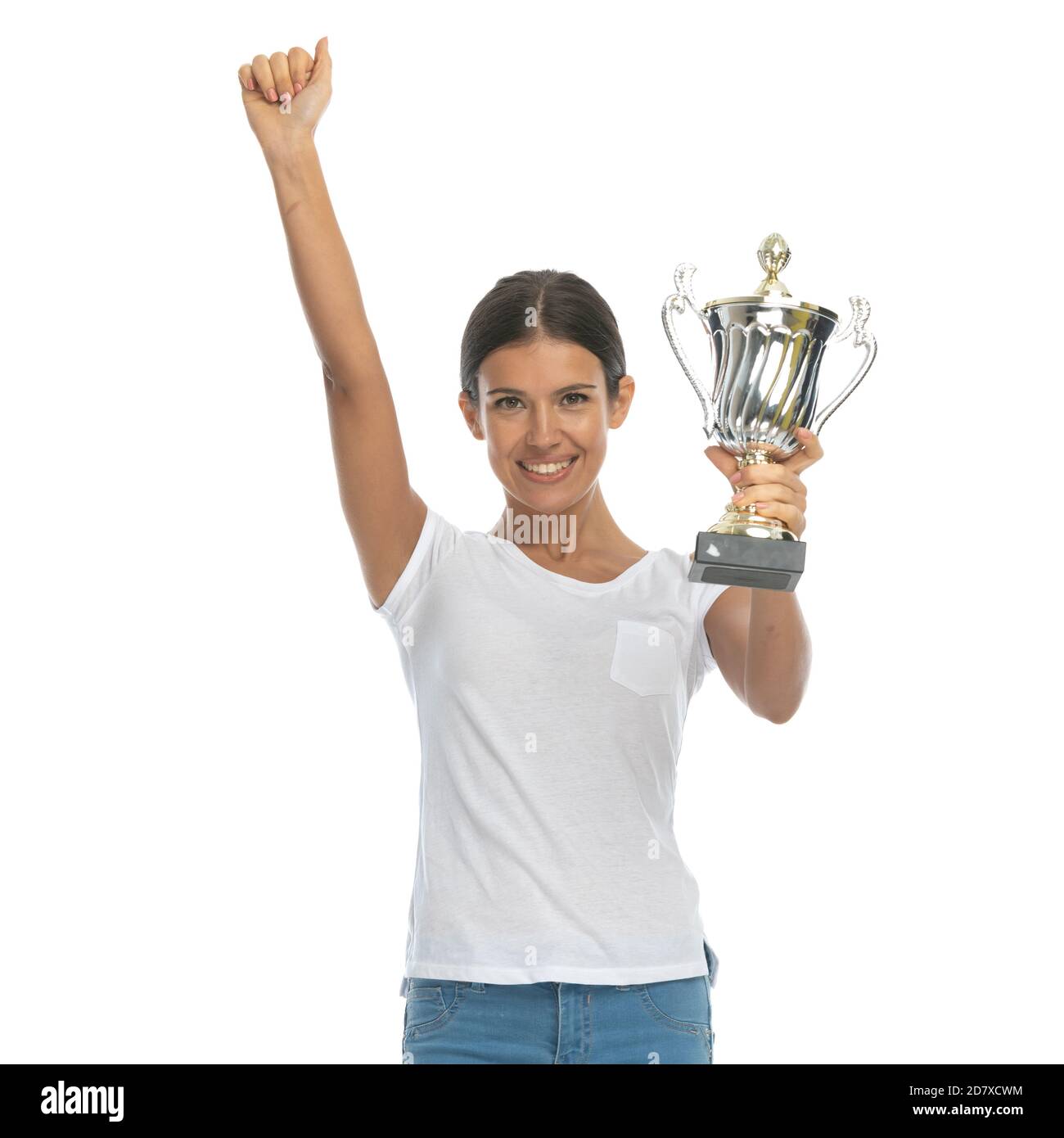 Cheerful casual woman holding trophy and celebrating while standing on ... Cheerful casual woman holding trophy and celebrating while standing on ...