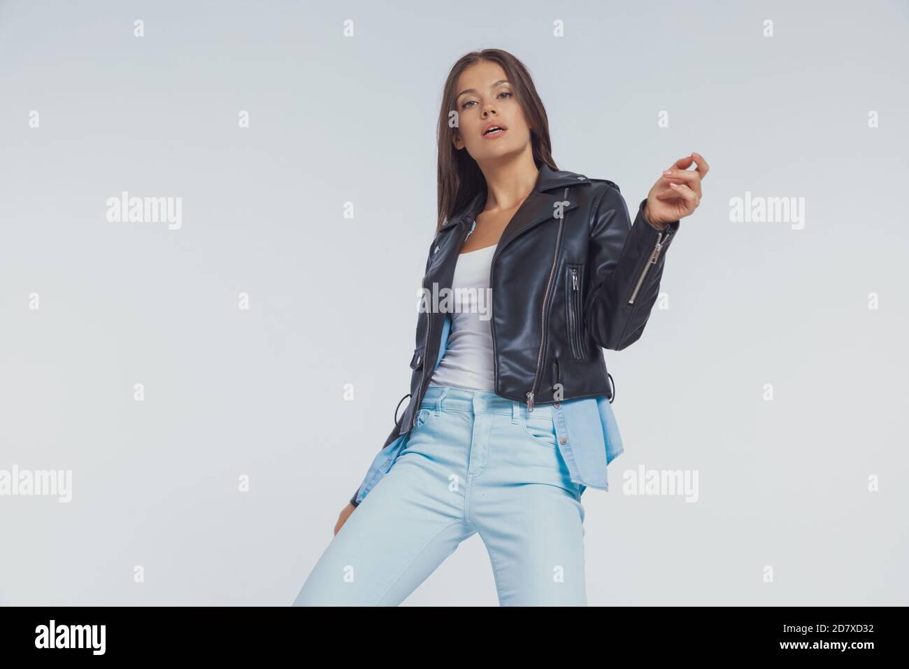 Bossy fashion model snipping her fingers, wearing leather jacket while ...