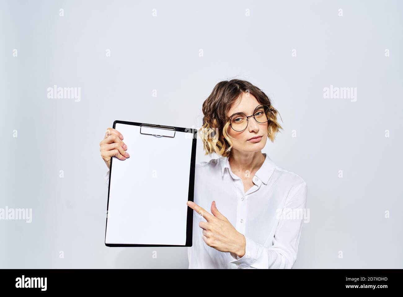 Business woman with a folder of white documents in her hand on a light ...