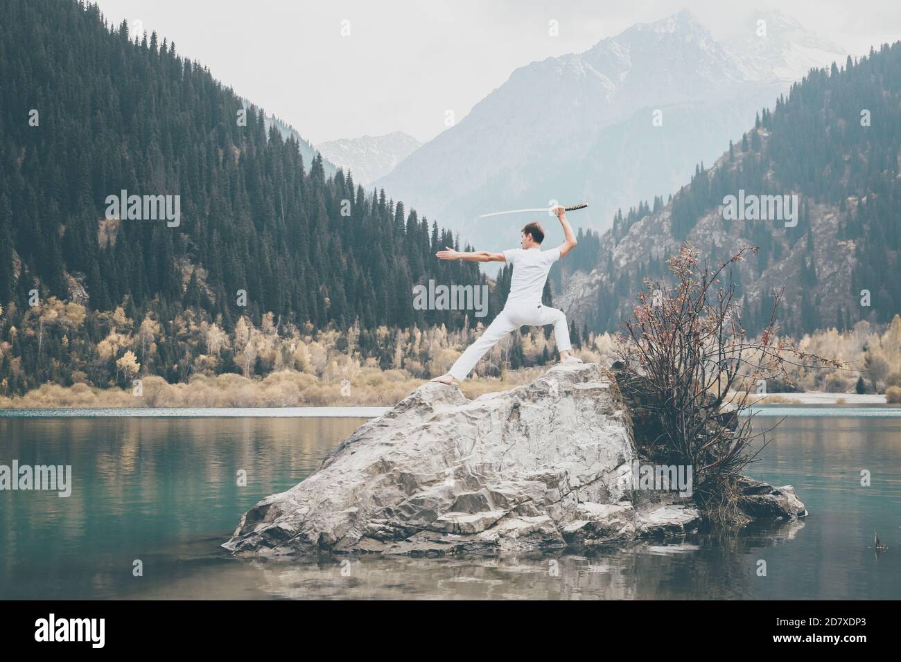A man holds a Japanese sword katana above his head. Training combat ...