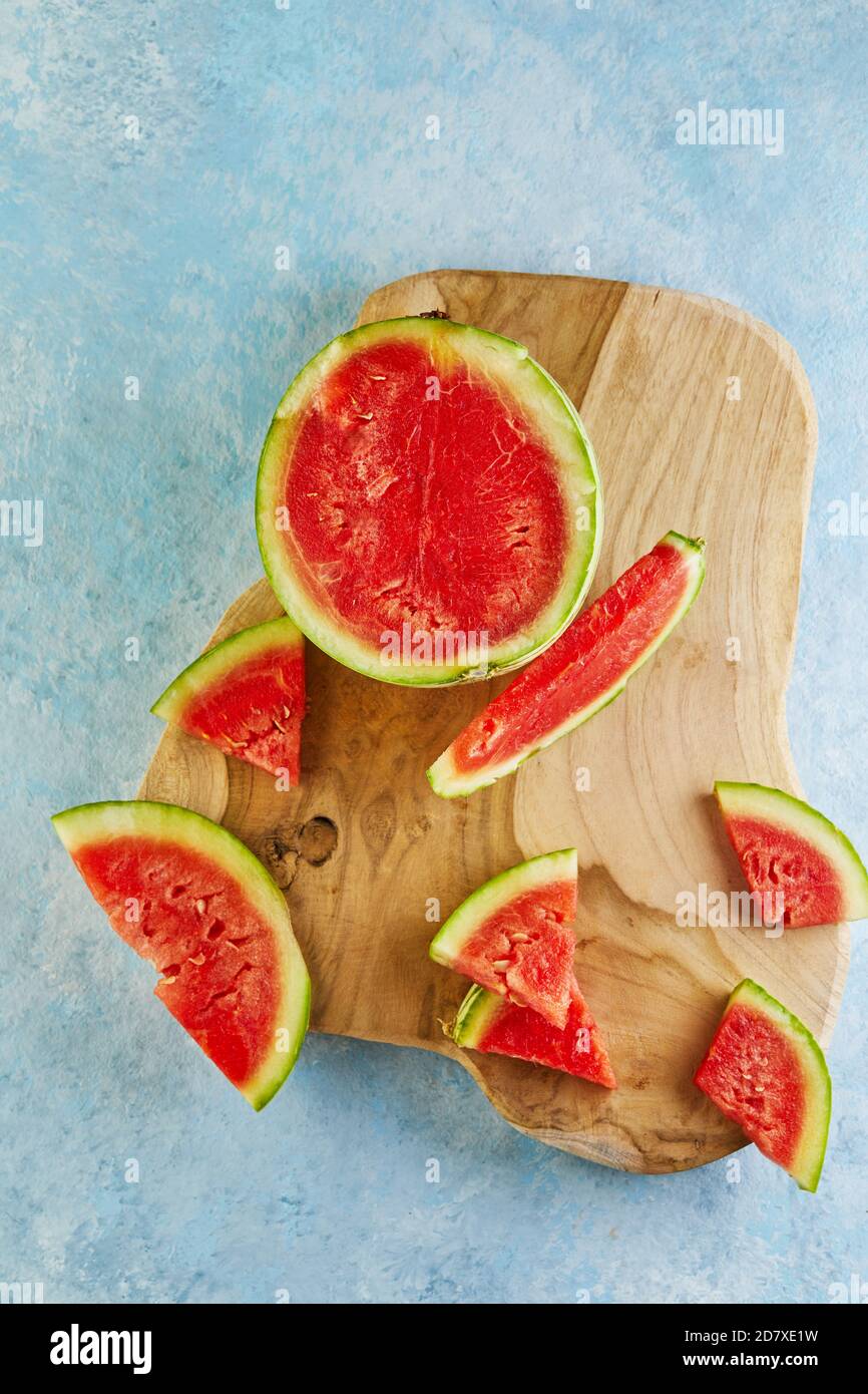 Mini Watermelon with sliced wedges on a light board on a light blue ...