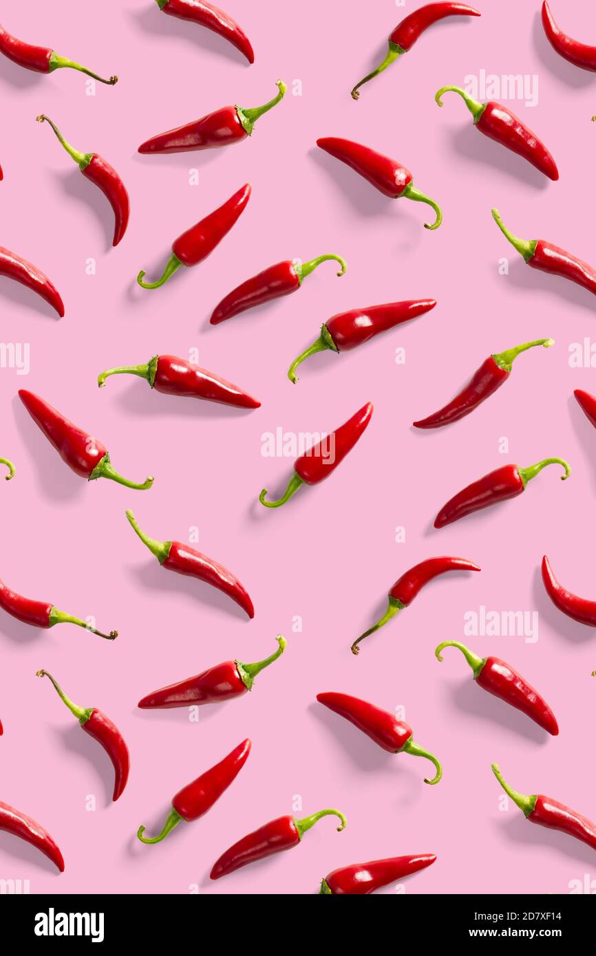Creative background made of red chili or chilli on pink backdrop ...