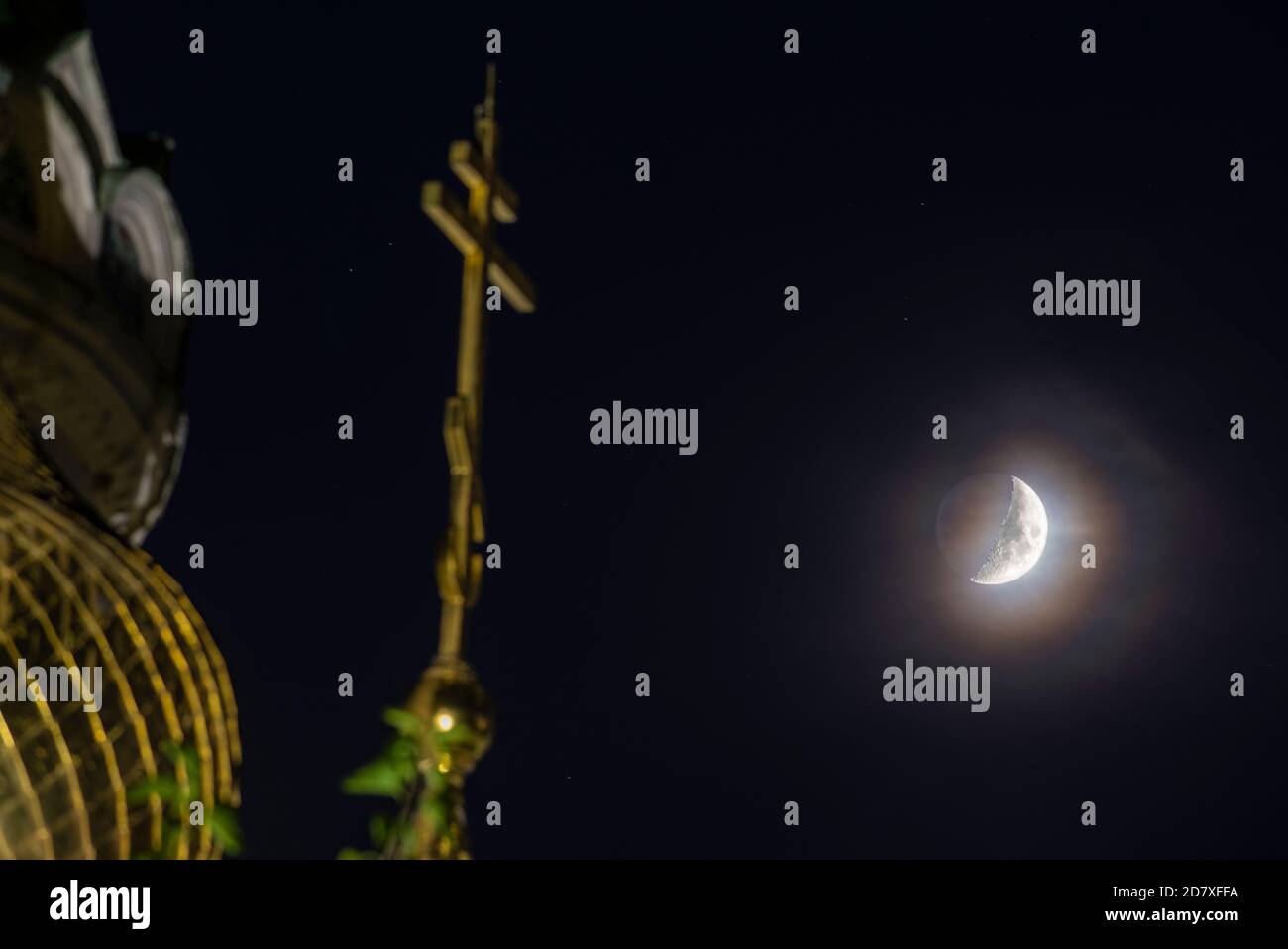 Moon in first quarter looking as lunar eclipse with blurred church ...