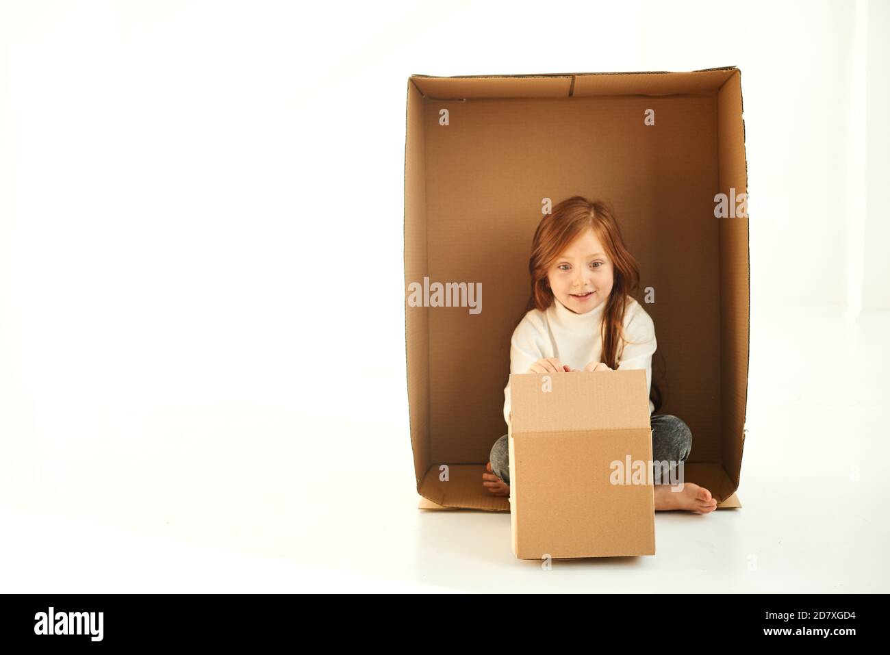 A little girl in a cardboard boxes at new home Stock Photo - Alamy