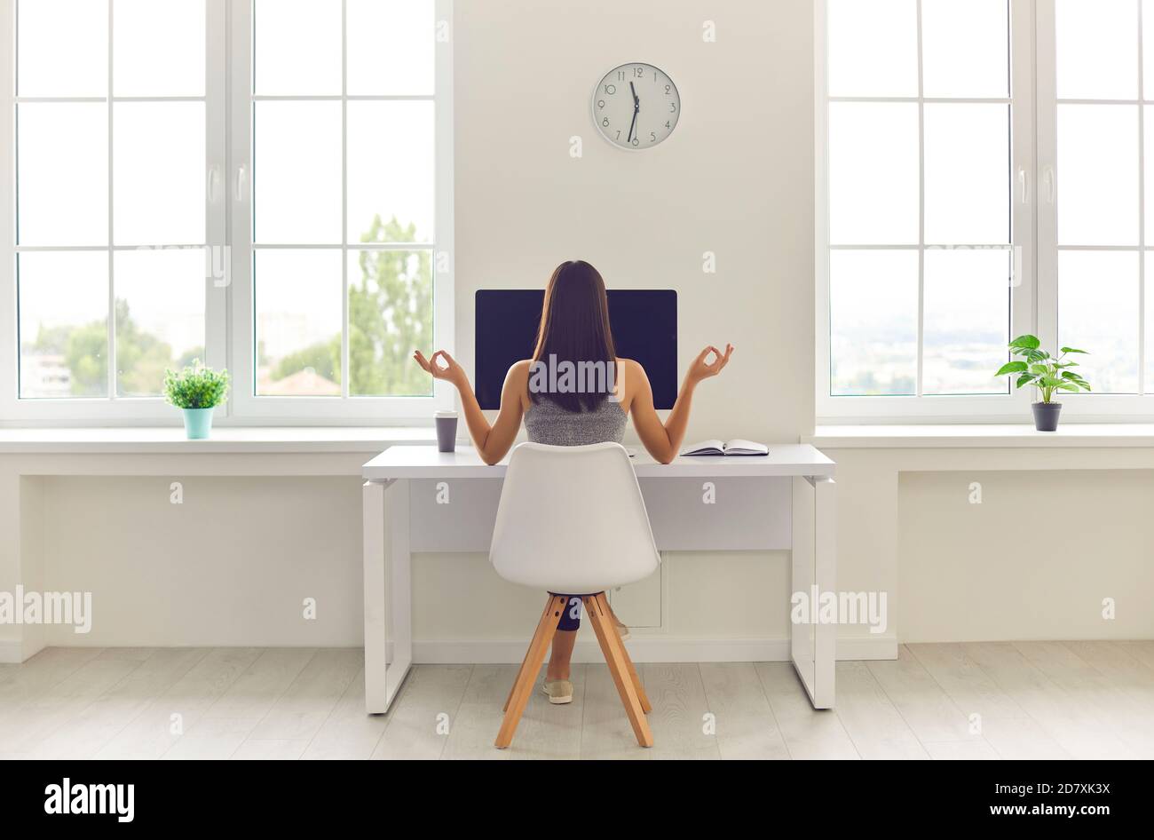 Woman taking break from work and meditating sitting at office table ...