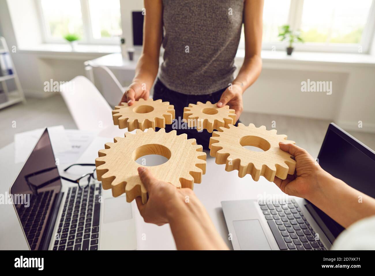 Businesspeople connecting gears as symbol of integration, teamwork and ...
