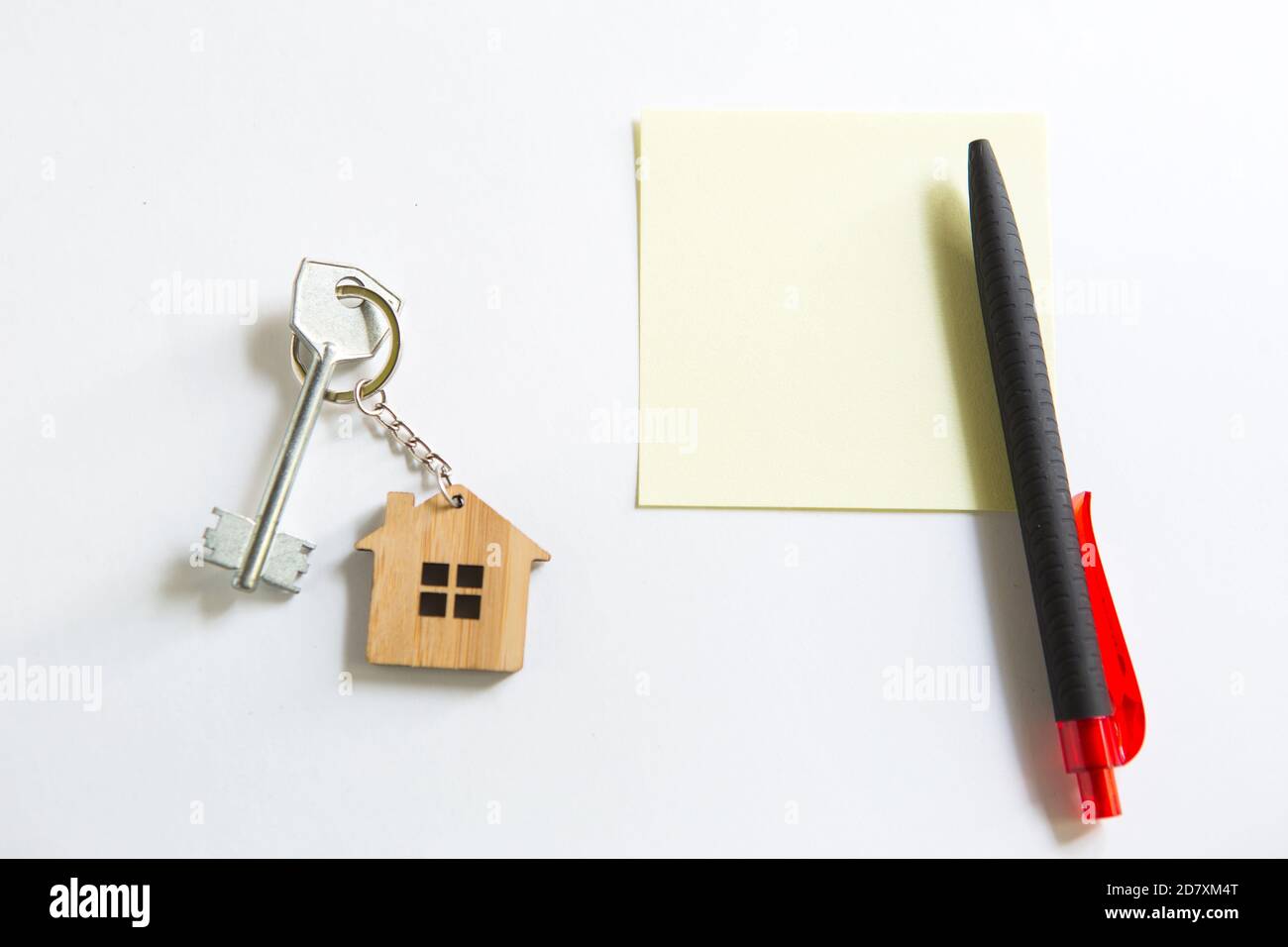 Keychain in the shape of wooden house with key on a white background ...
