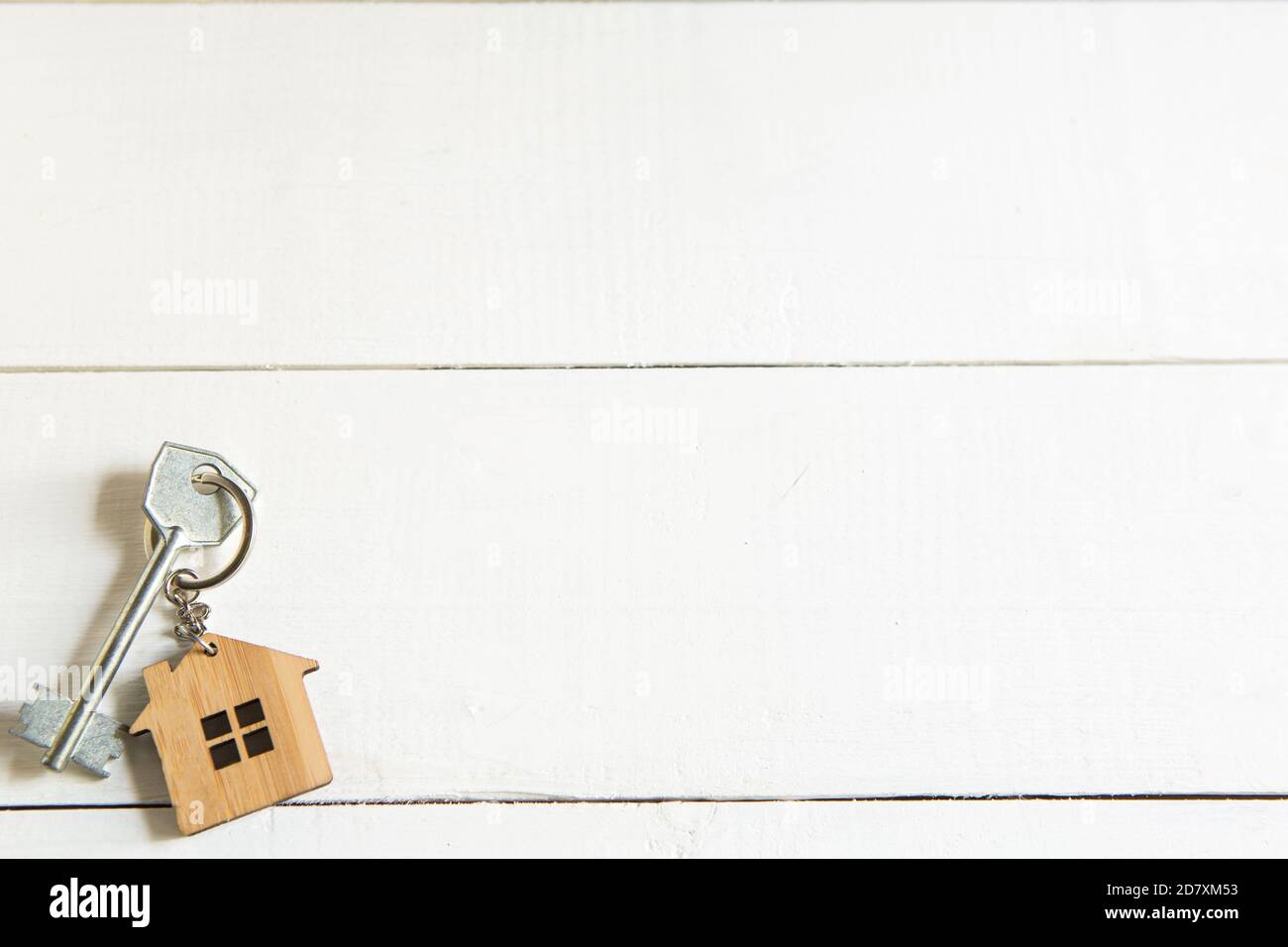 Keychain in the shape of wooden house with key on a white background ...