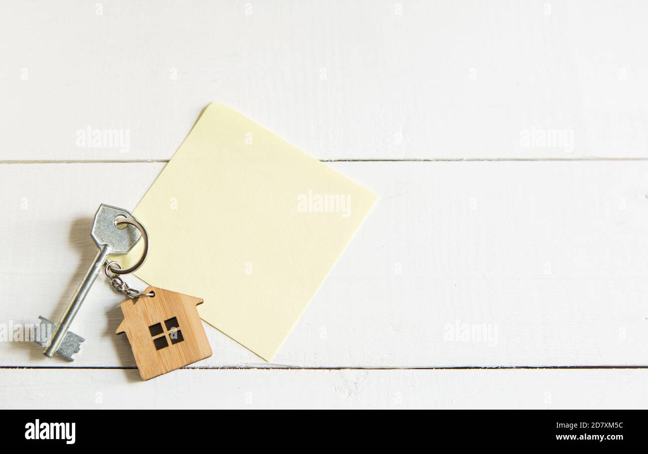Keychain in the shape of wooden house with key on a white background ...