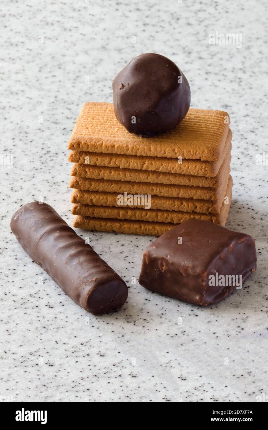 Rectangular shortbread cookies and chocolates on a light marble top ...