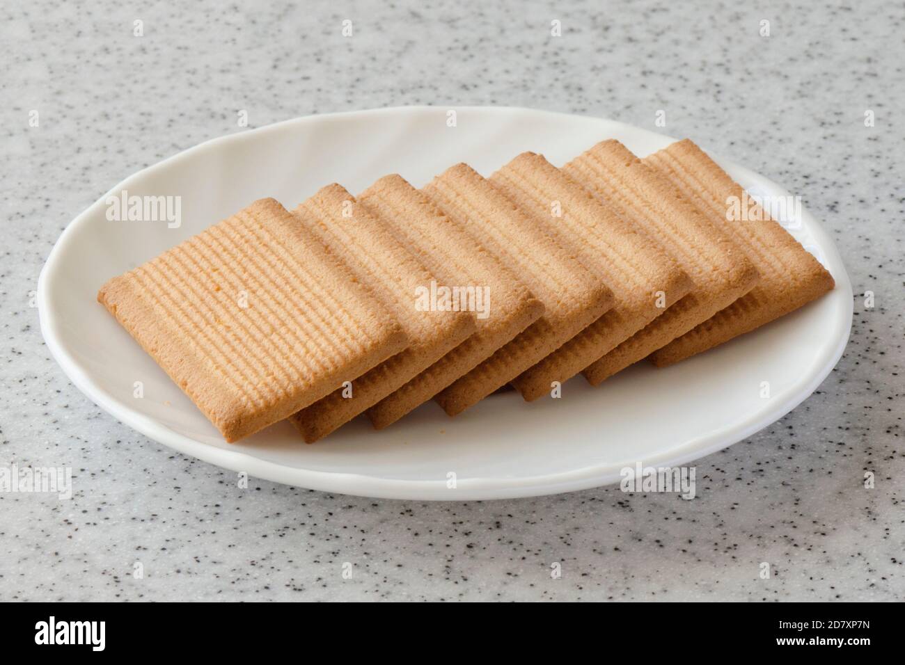 Rectangular shortbread cookies and chocolates in a white plate on a ...