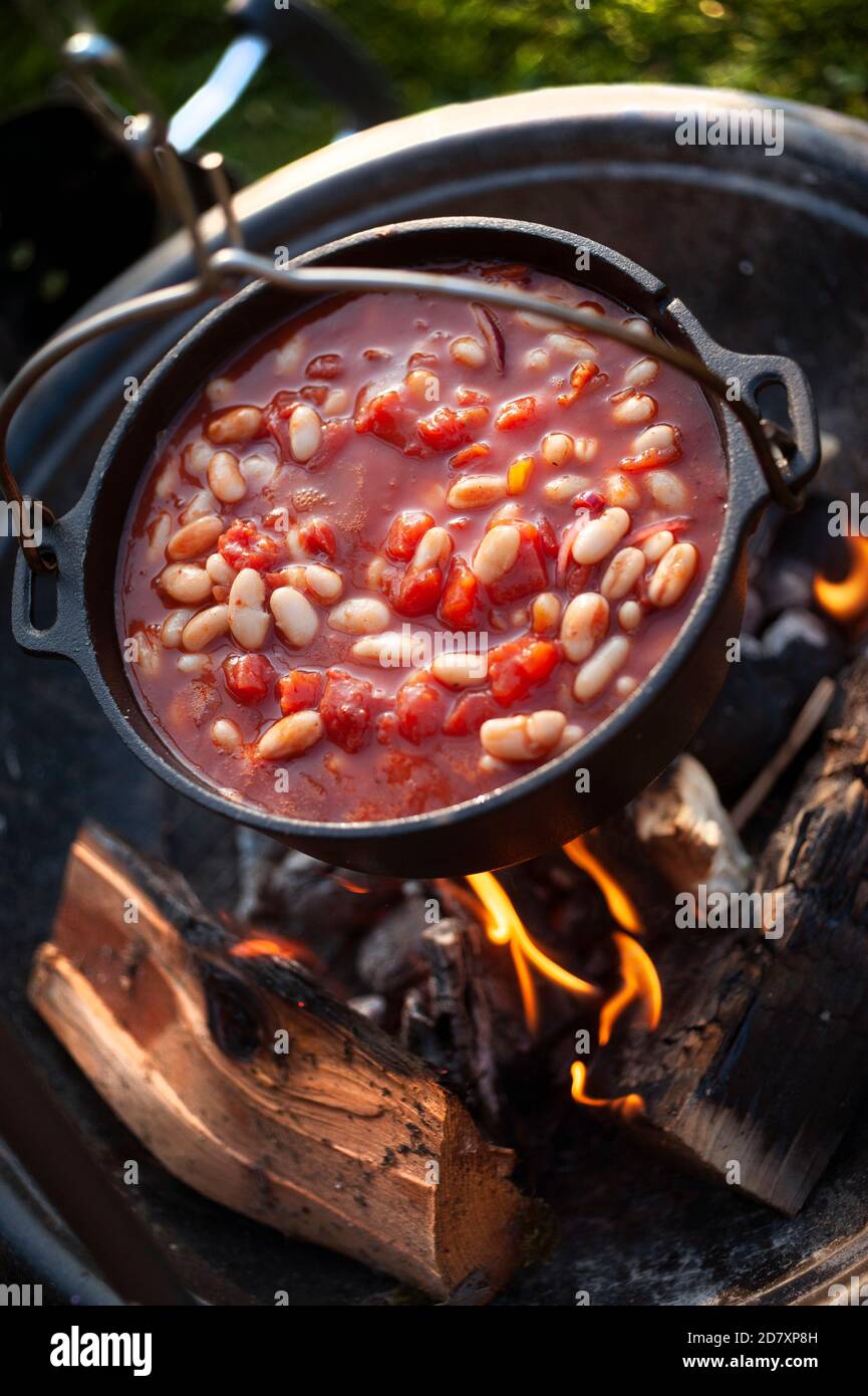 Spicy chorizo,bean,tomato and egg stew cooking over fire pit Stock ...