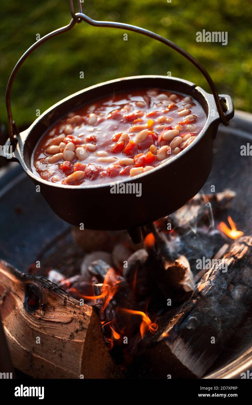 Spicy chorizo,bean,tomato and egg stew cooking over fire pit Stock ...