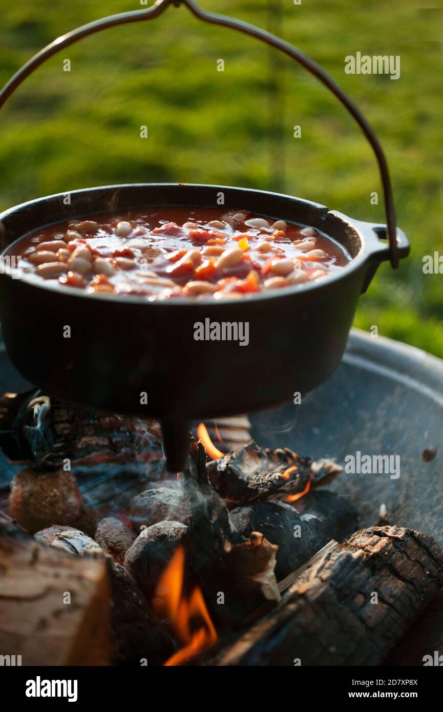 Spicy chorizo,bean,tomato and egg stew cooking over fire pit Stock ...