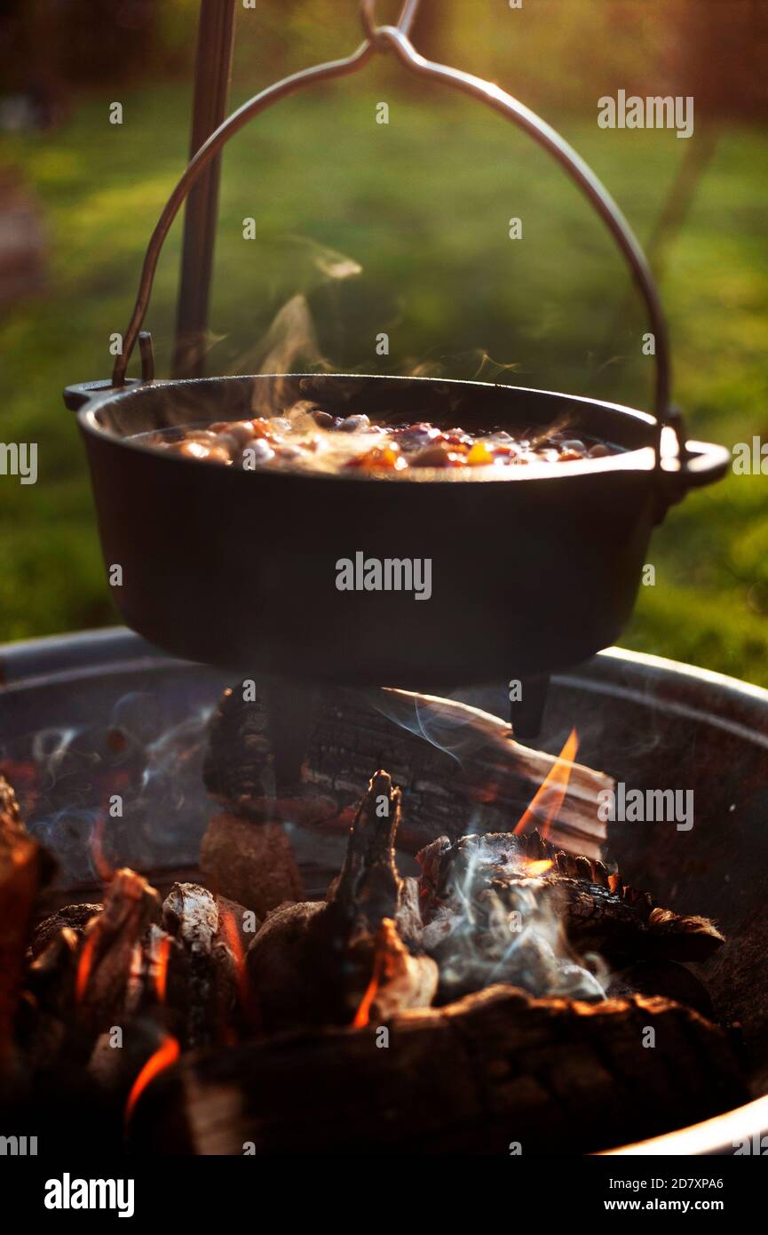 Spicy chorizo,bean,tomato and egg stew cooking over fire pit Stock ...