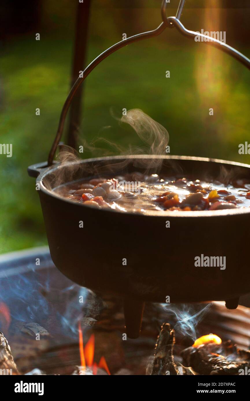 Spicy chorizo,bean,tomato and egg stew cooking over fire pit Stock ...
