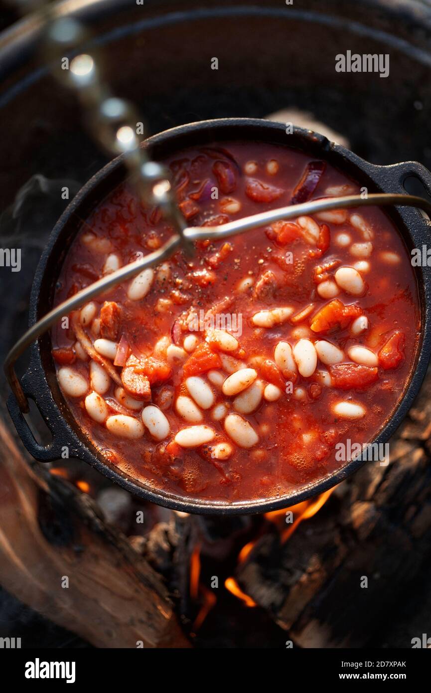 Spicy chorizo,bean,tomato and egg stew cooking over fire pit Stock ...