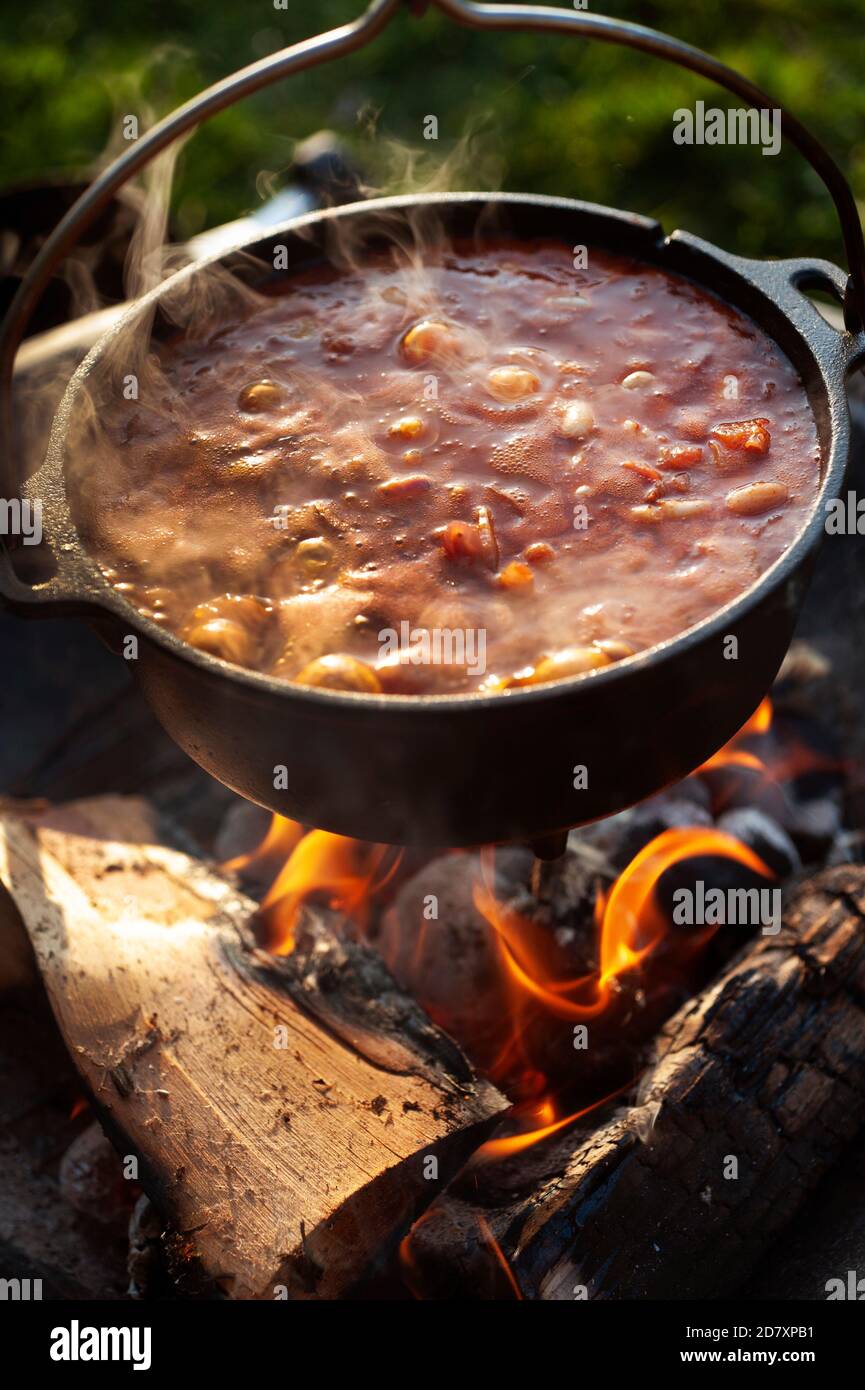 Spicy chorizo,bean,tomato and egg stew cooking over fire pit Stock ...