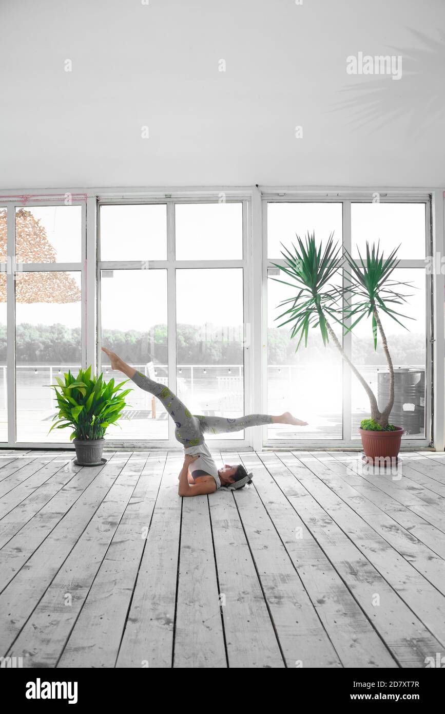 Woman doing supported shoulder stand pose during her indoor yoga class ...