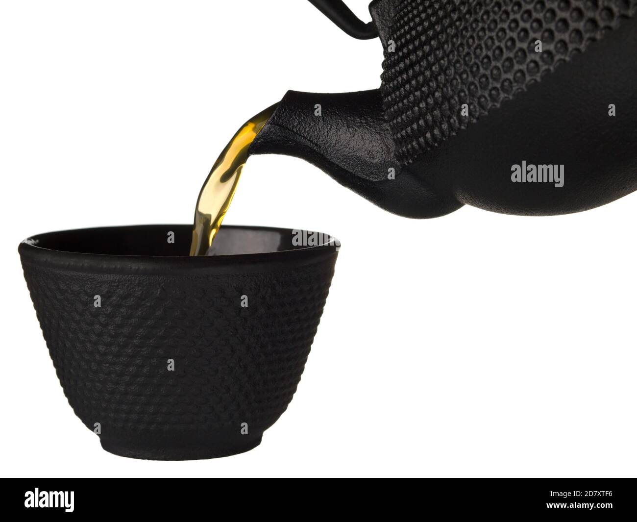 Tea pouring to black cup isolated. Tea ceremony. Stream of tea from a ...